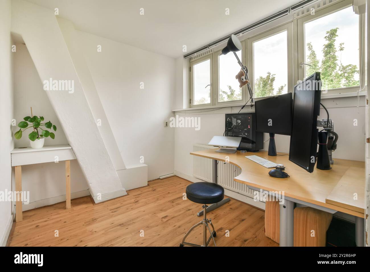A modern, well-lit home office featuring dual computer monitors, a ...