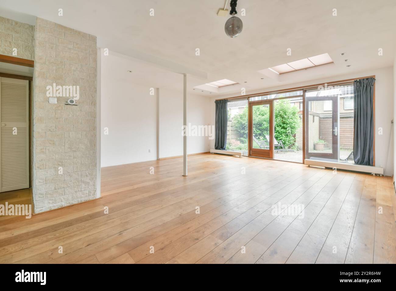 An empty modern living room with large windows offering a scenic view ...