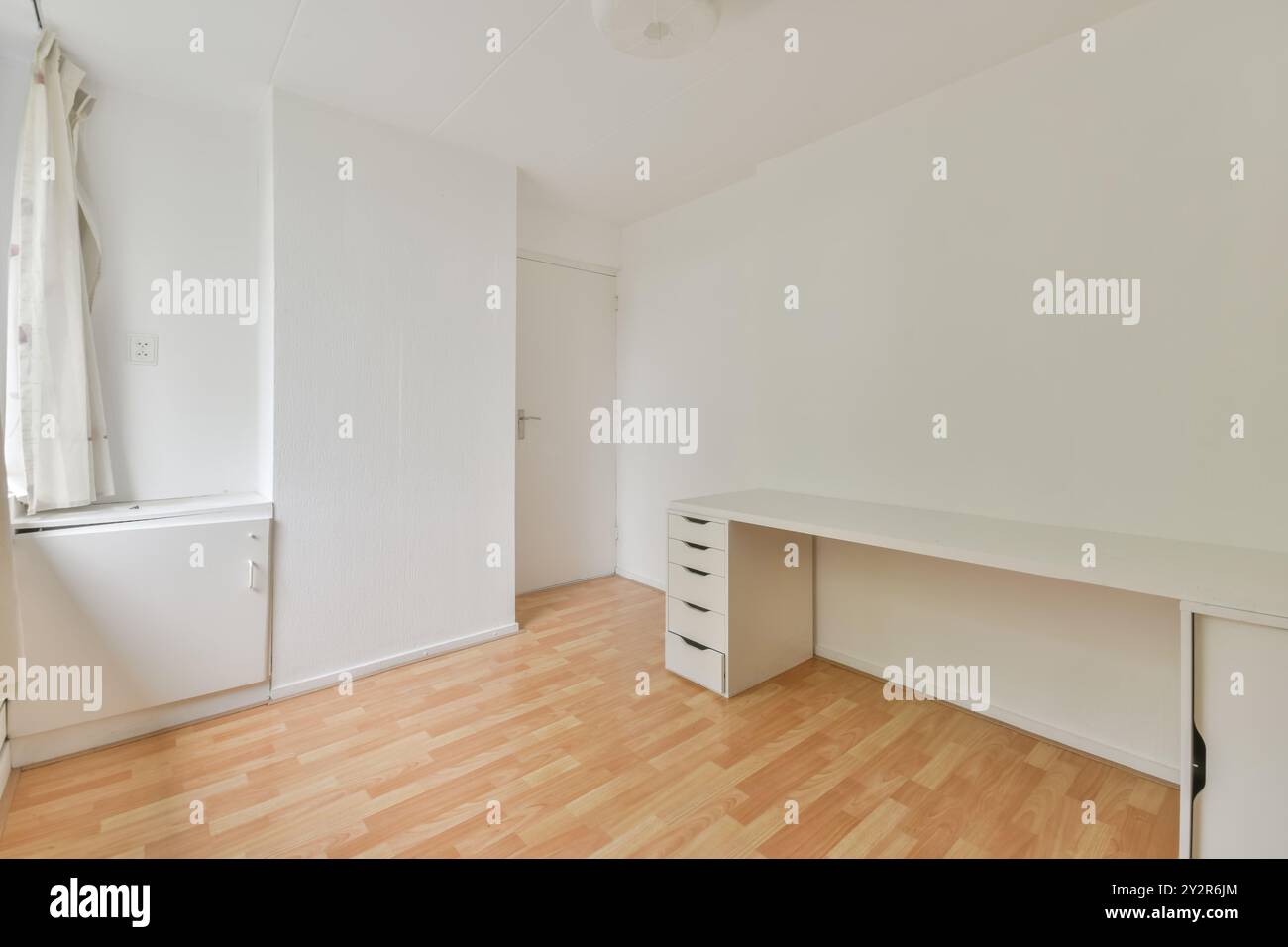 Empty small room with herringbone parquet floor and built-in desk and ...