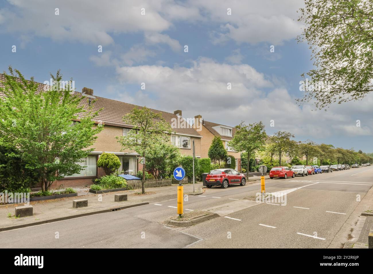 A peaceful suburban street lined with terraced houses, lush greenery ...
