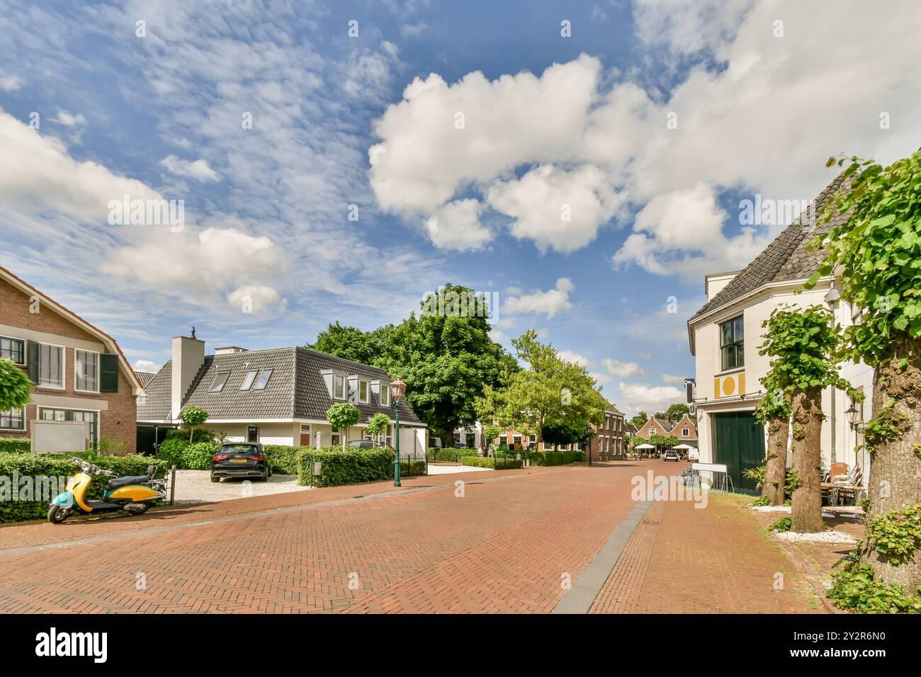 A peaceful street in a residential area lined with modest houses under ...