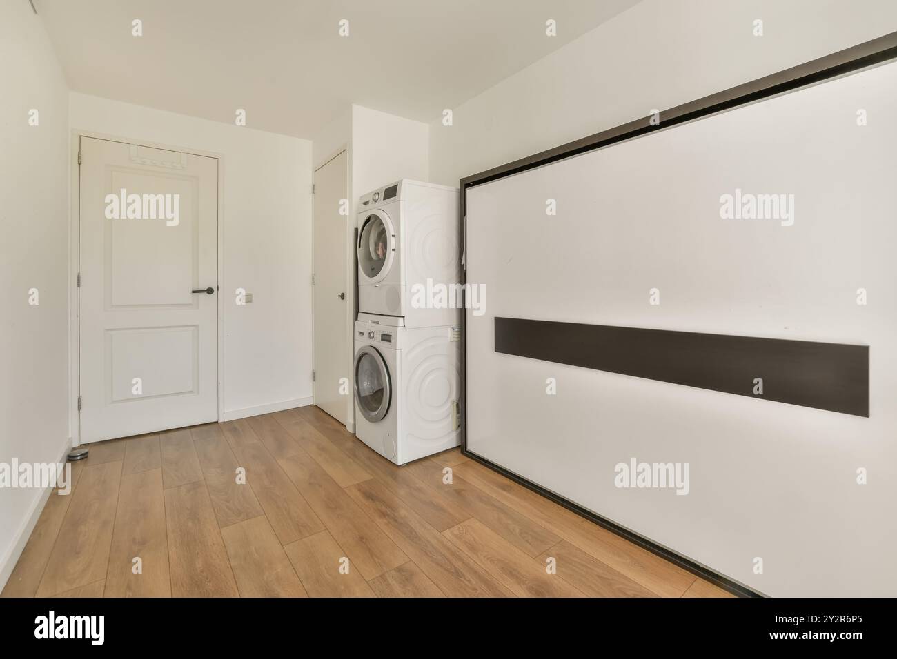 A , modern laundry room featuring a stacked washing machine and dryer ...