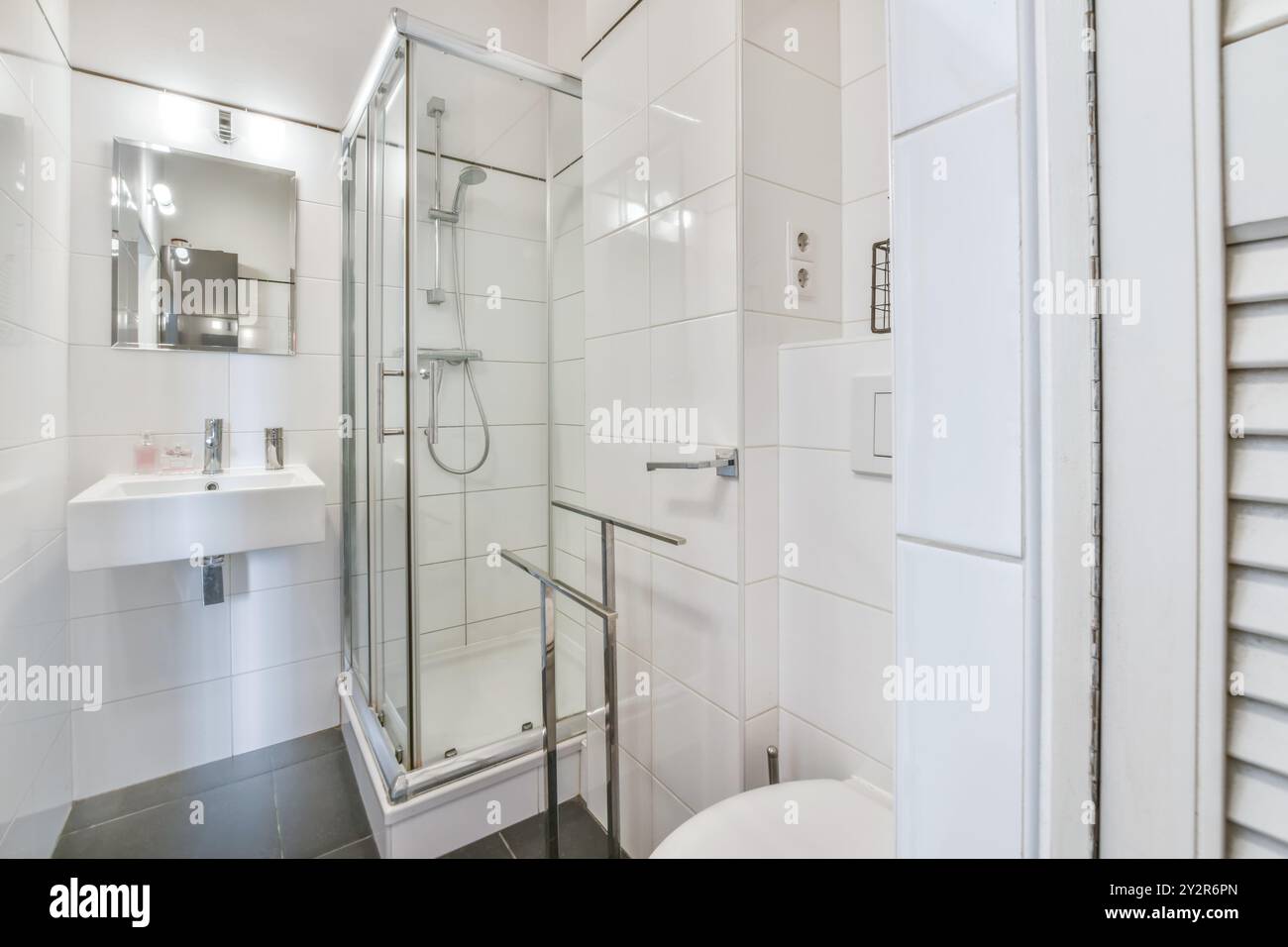 Bright and sleek bathroom featuring a glass shower cubicle, white basin ...