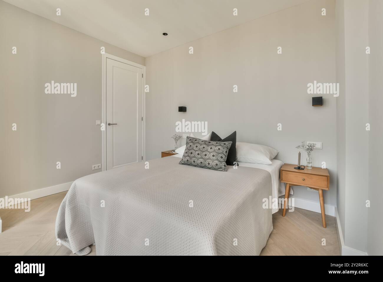 A contemporary bedroom featuring a neat bed with stylish pillows ...