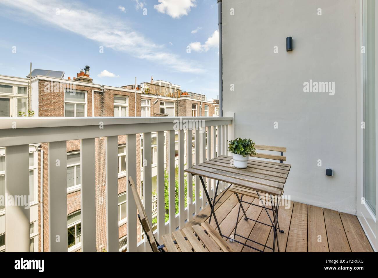 A quaint balcony of an apartment featuring wooden flooring, a small ...