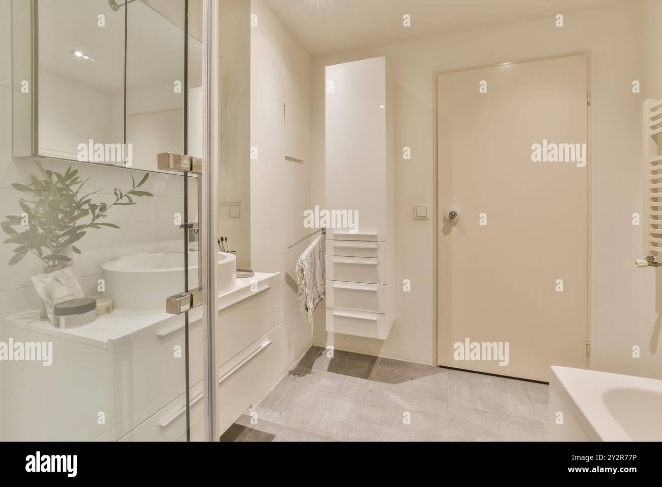 A contemporary bathroom featuring a white basin, bathtub, mirror, and ...