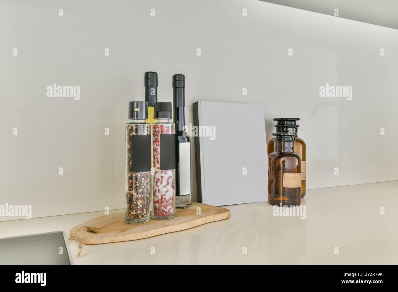 Modern kitchen countertop displaying glass bottles of oil and spices ...