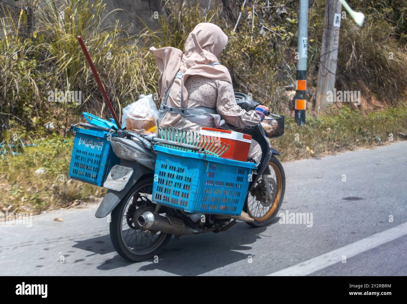 BETONG, THAILAND, MAR 02 2024, An woman is carrying a load on a ...