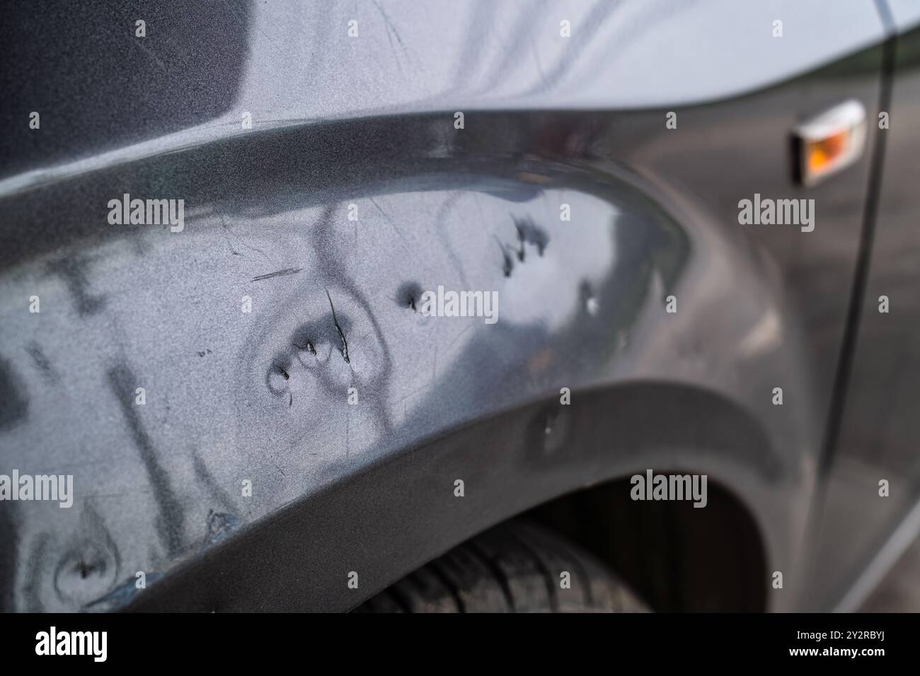 Scratched and damaged from dog on metal part of grey car around wheel ...