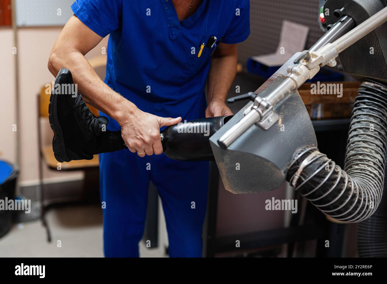 A skilled technician in blue scrubs meticulously adjusting a prosthetic ...