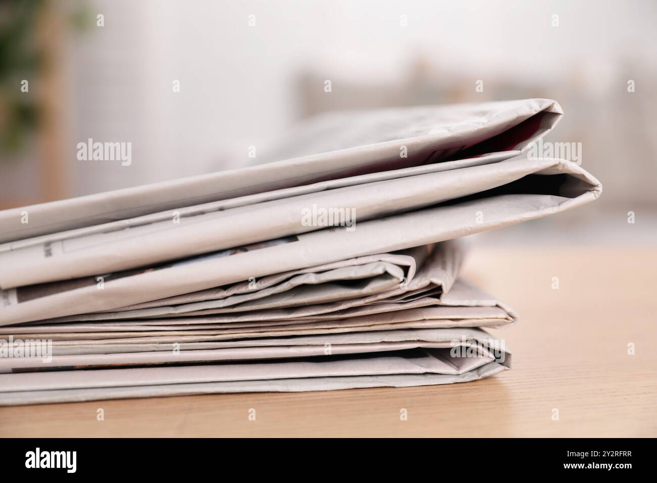 Stack of newspapers in different languages on table indoors, closeup ...
