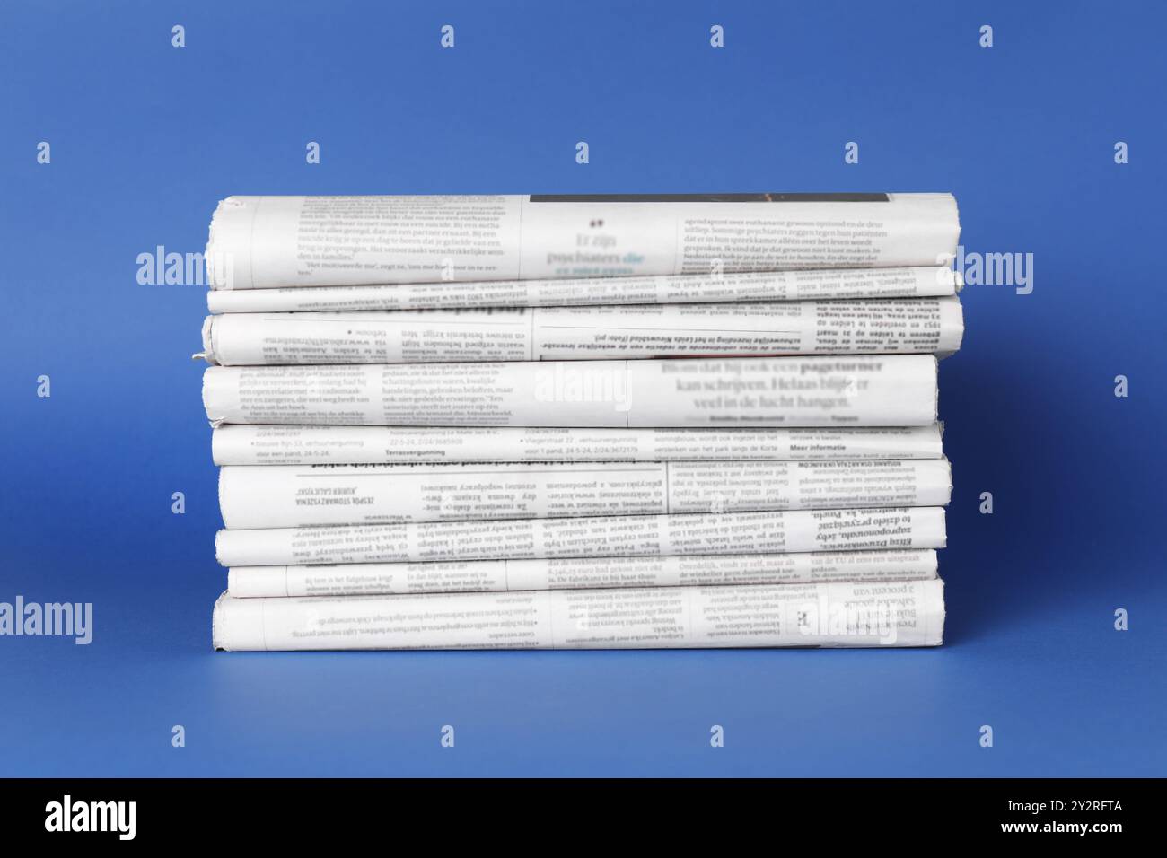 Stack of many newspapers in different languages on blue background ...