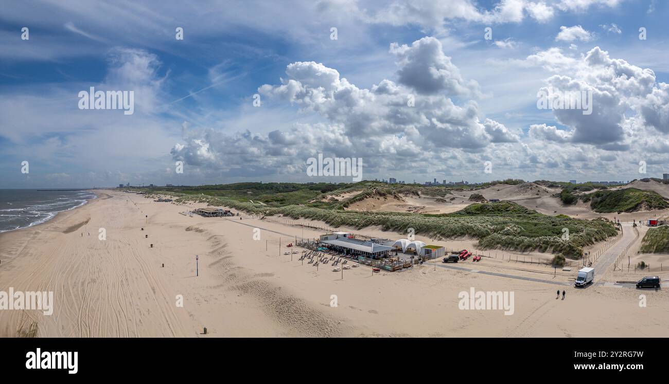 A beachside venue with seating arrangements and structures is nestled ...