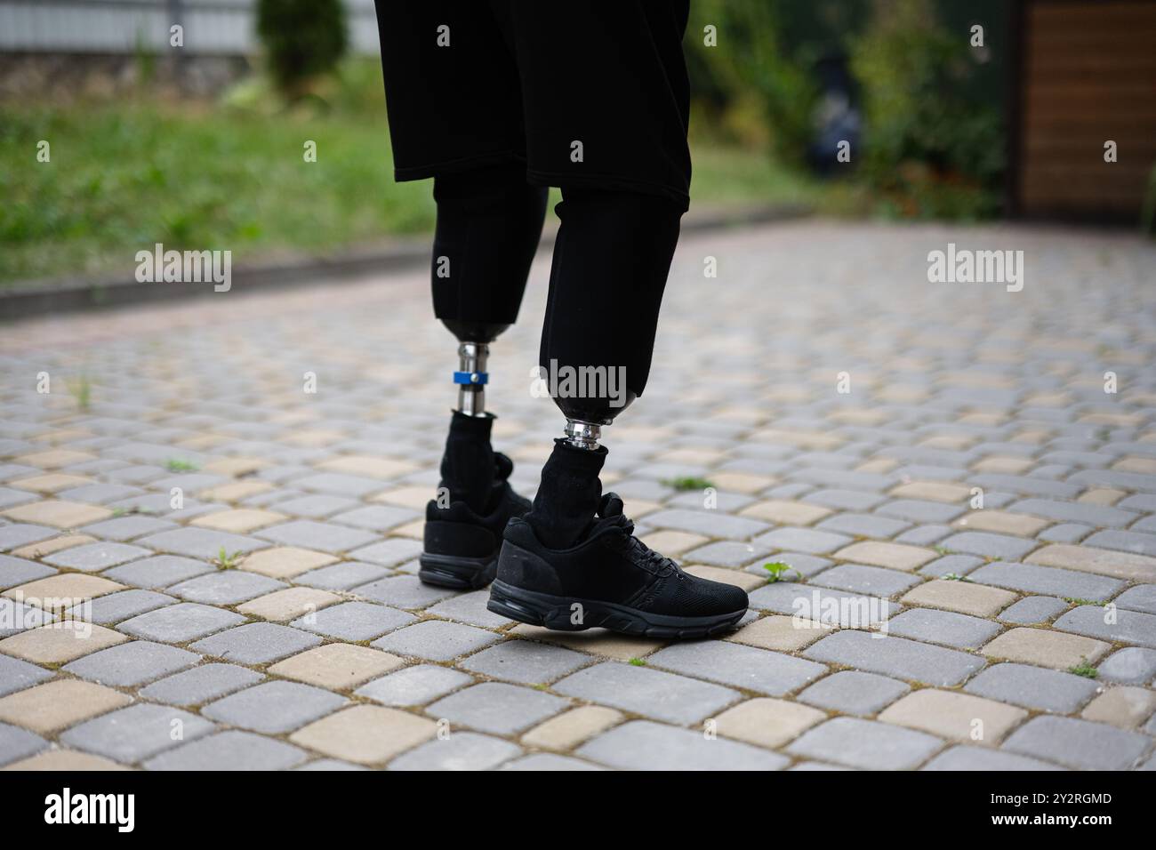 A close-up image of an individual with prosthetic legs wearing black ...