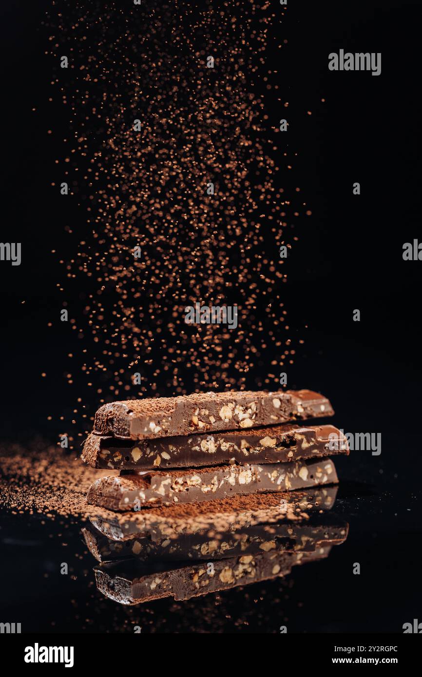 Chocolate bars with nuts and cocoa powder falling, captured in a ...