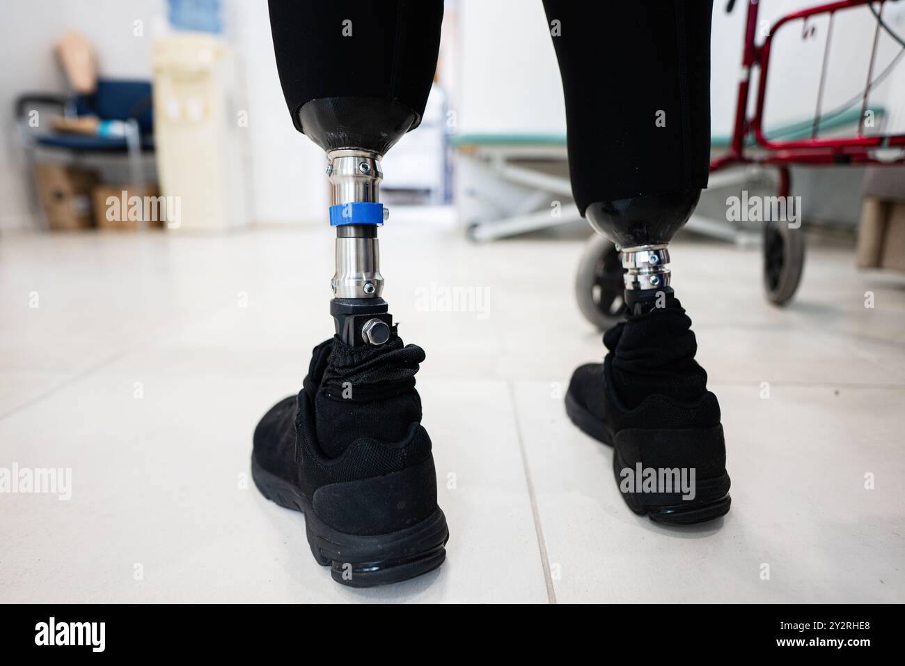A detailed view of prosthetic legs fitted with black athletic shoes ...