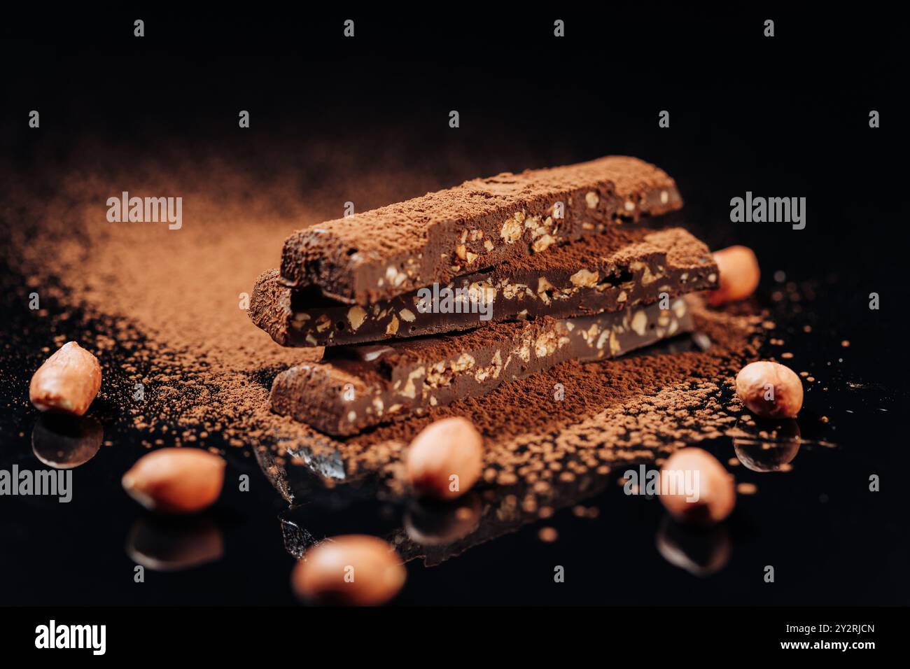Chocolate bars with nuts and cocoa powder falling, captured in a ...