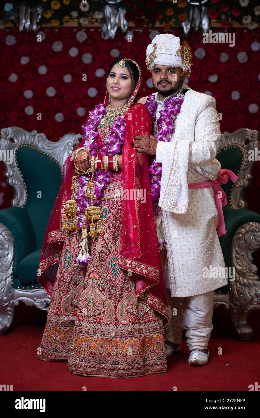 Indian bride and groom in traditional wedding attire posing for a photo ...