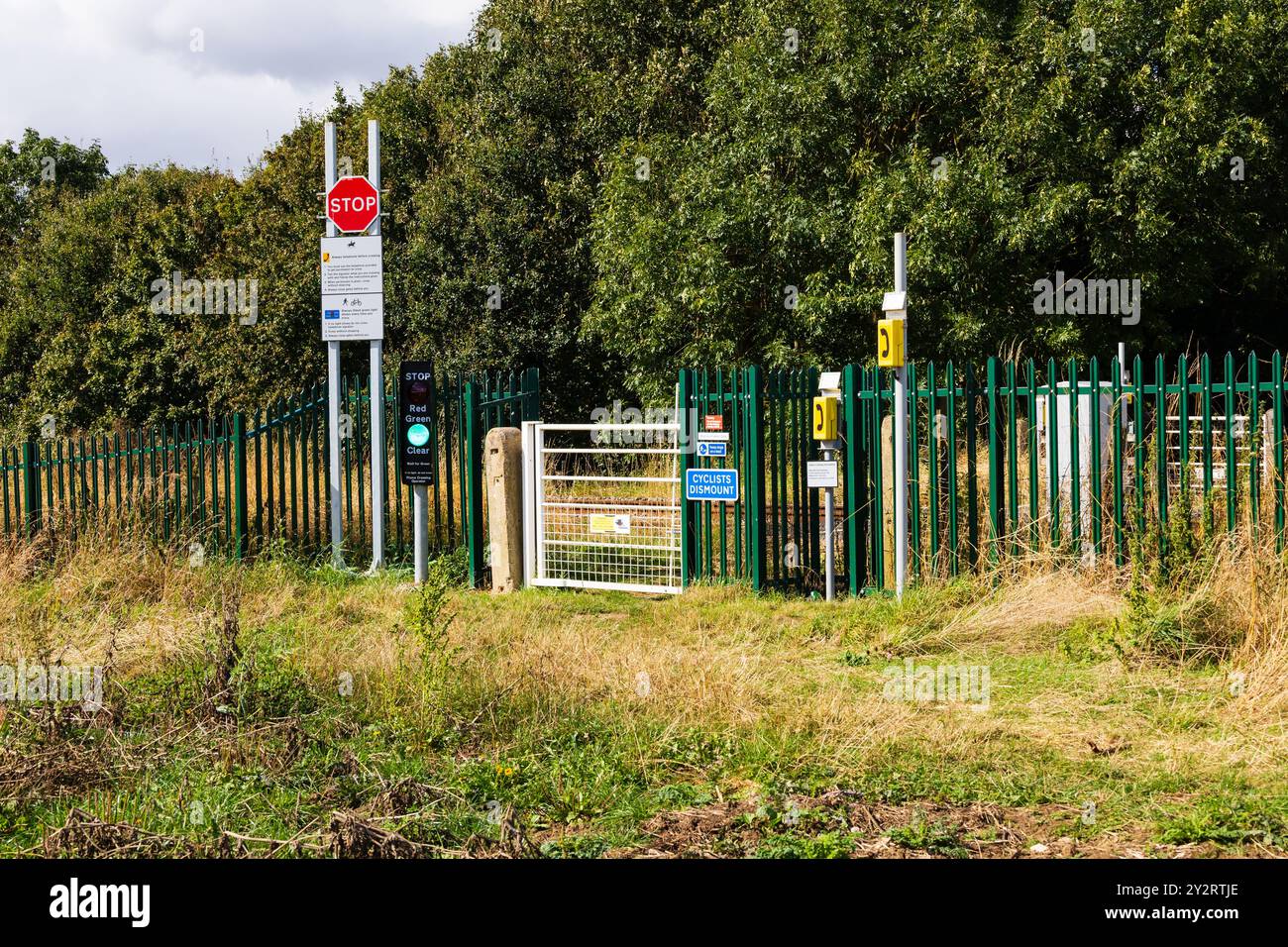 Mill railway level crossing with warning signs and lights. near ...