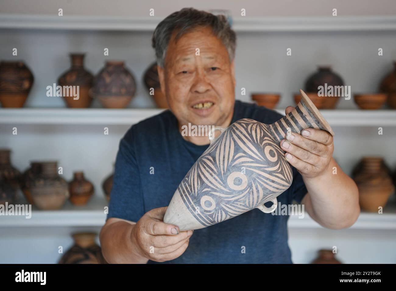 Lintao. 11th Sep, 2024. Yan Jianlin showcases his pottery work in the ...