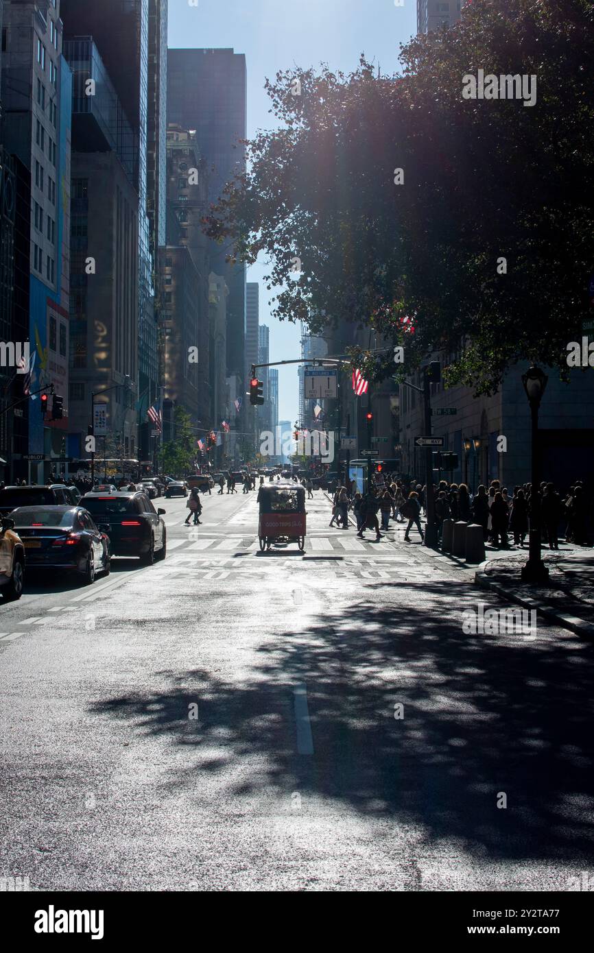 A busy urban street scene with pedestrians and vehicles in the ...
