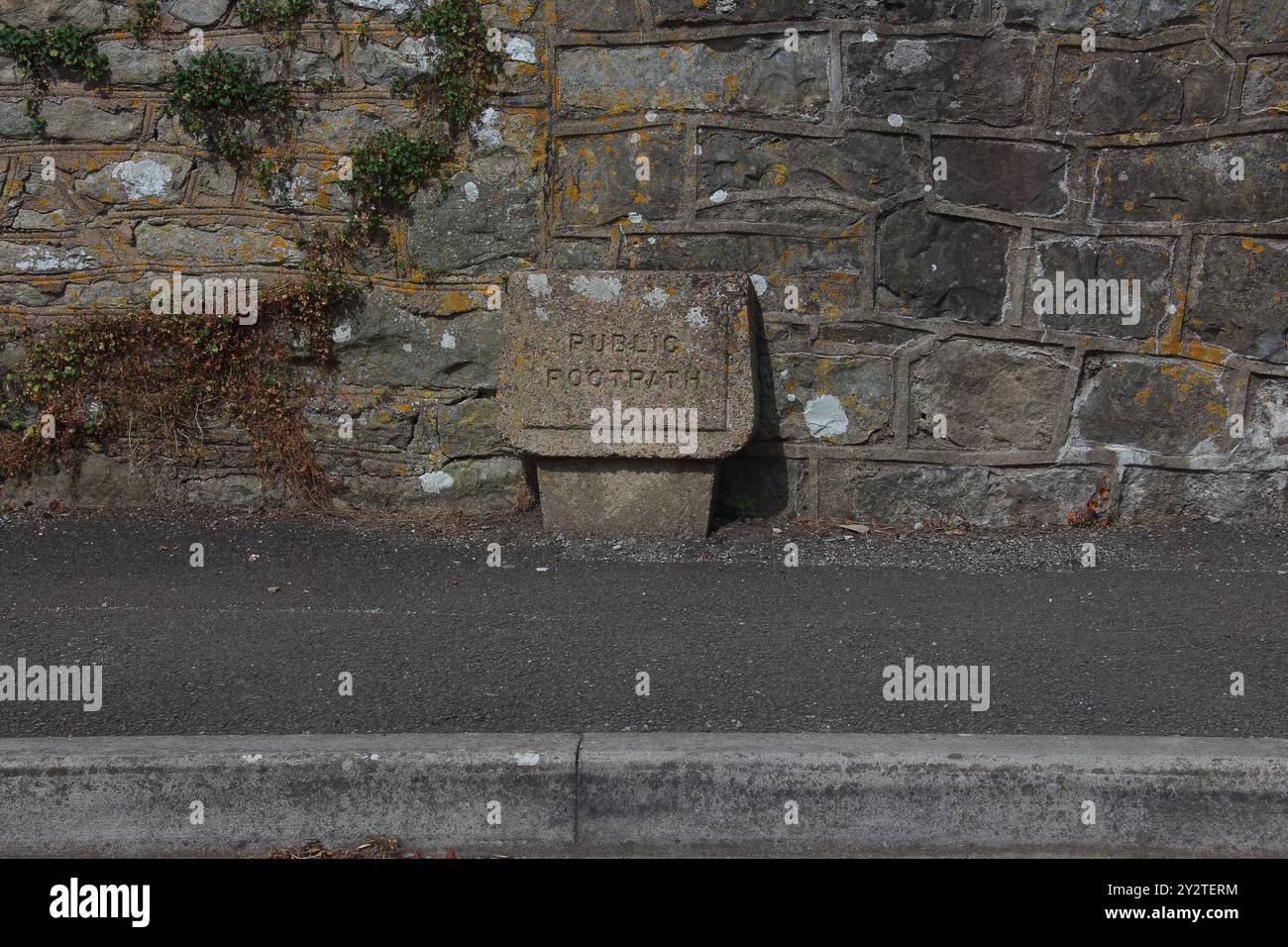 A rather unusual concrete Public footpath sign at the side of the ...