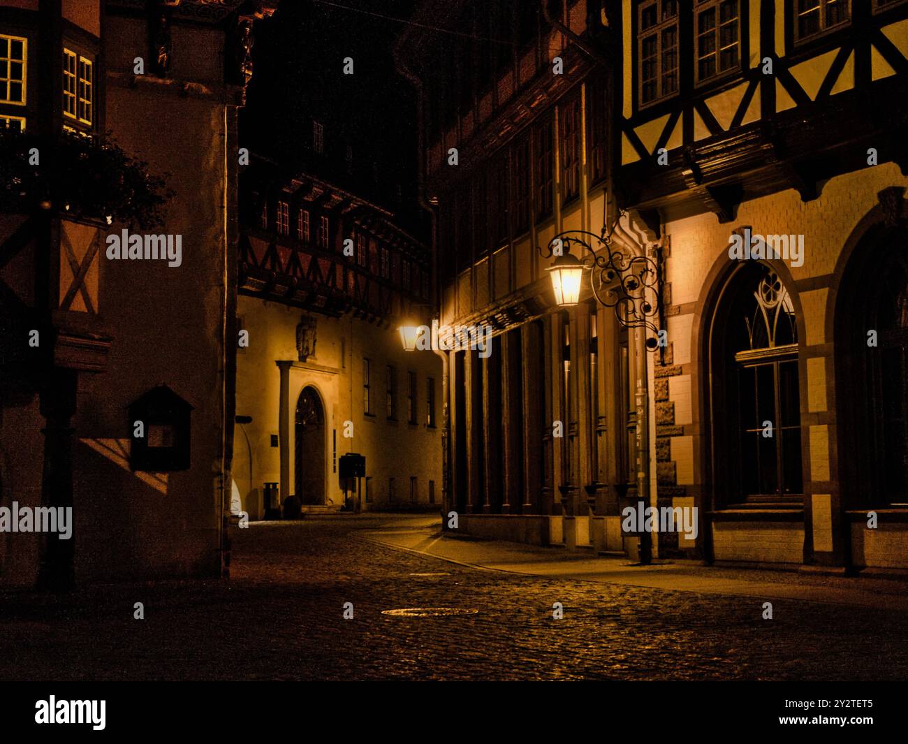 A charming night view of a cobblestone street in a historic European ...