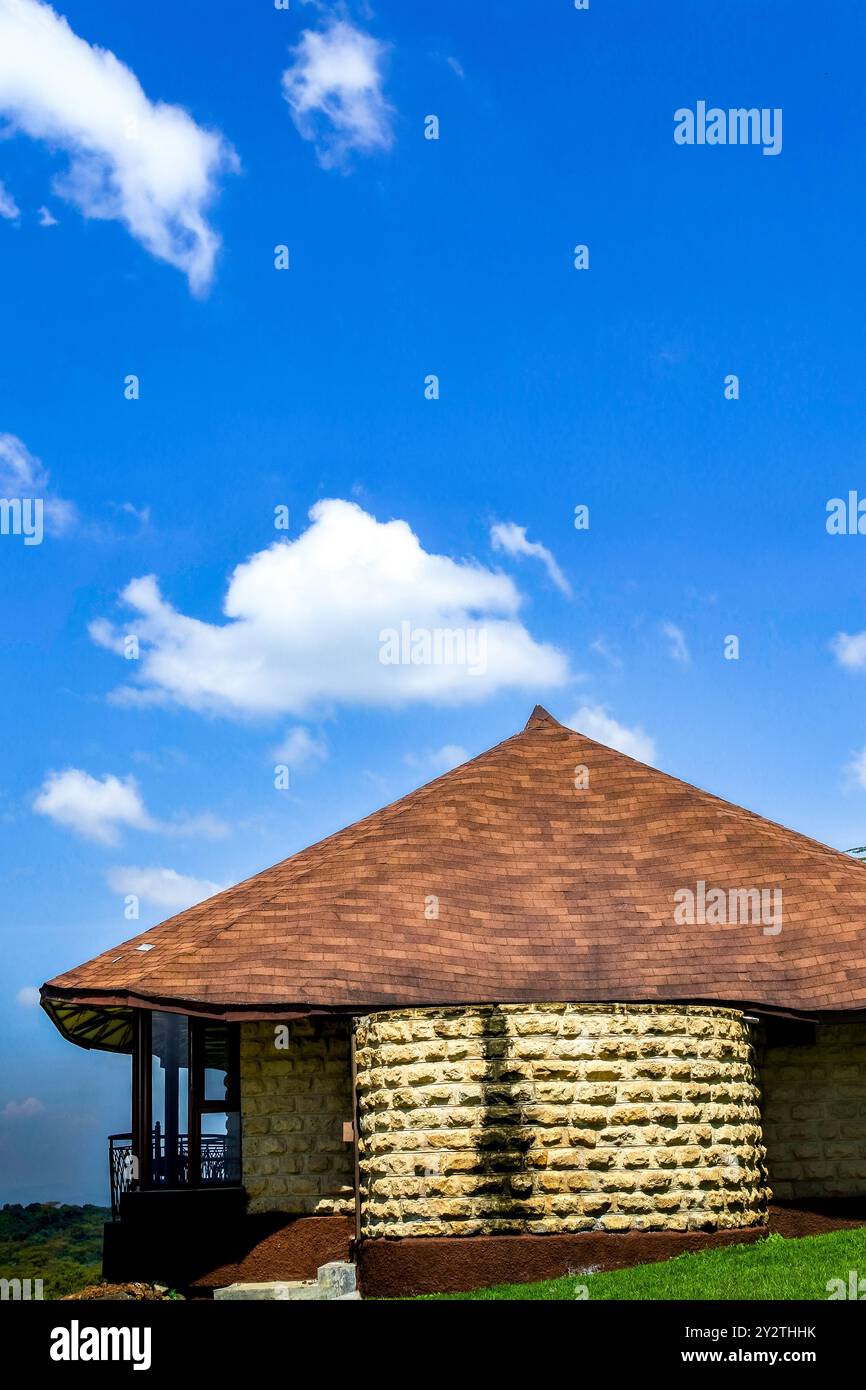 A beautiful stone house with a unique roof design under a clear blue ...
