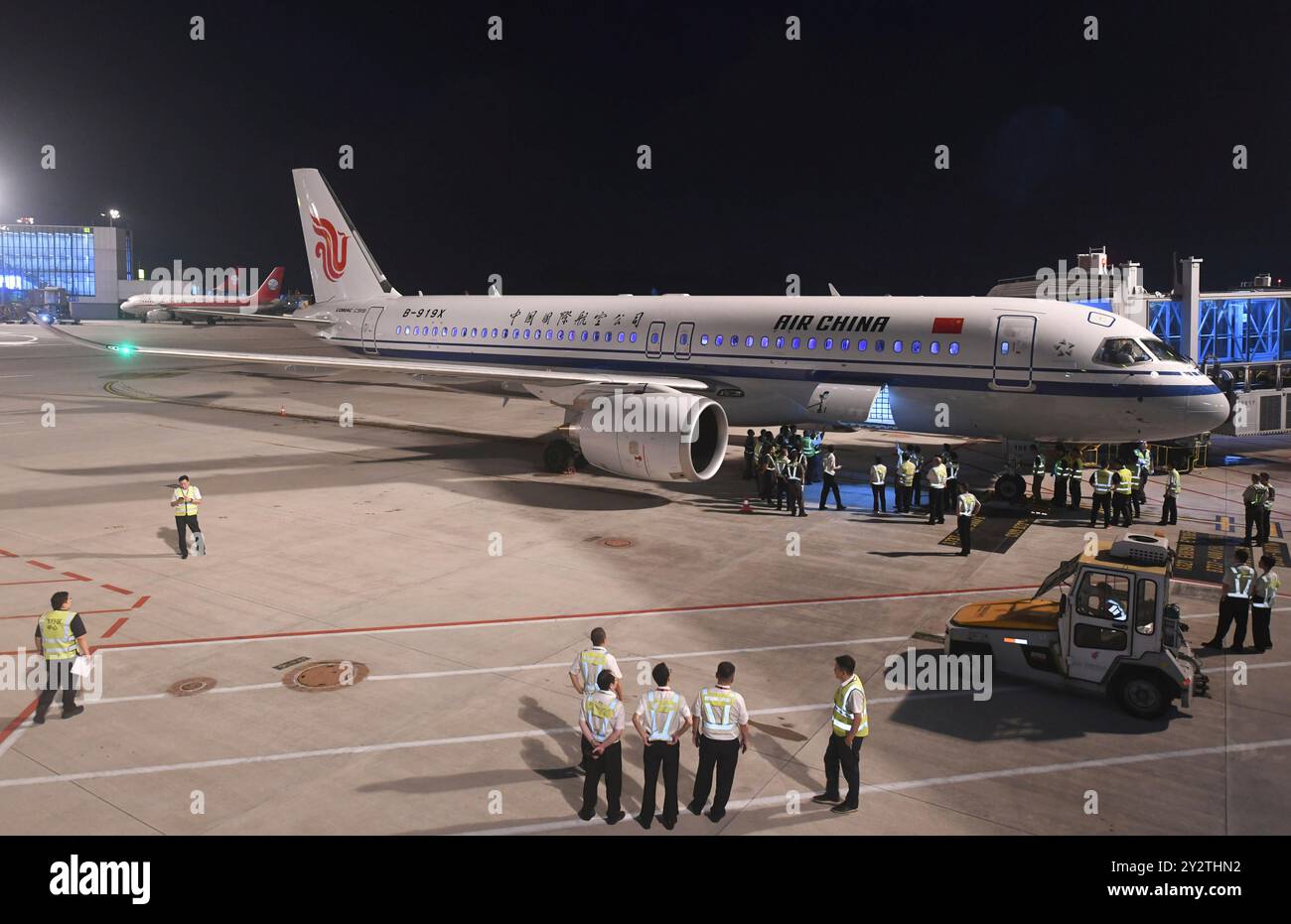 Workers celebrate the airport's first flight of Comac C919 aircraft in ...