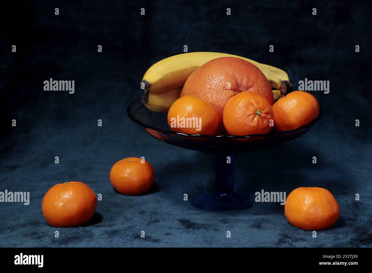 The low key depicts a fruit bowl filled with tangerines, bananas and ...