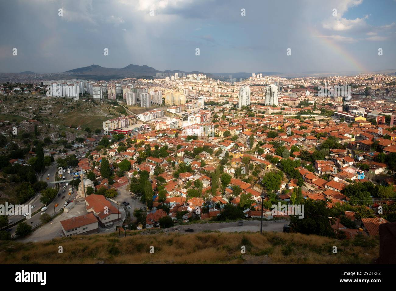 Hillside town sprawls over rocky terrain, red-roofed houses dotting the ...