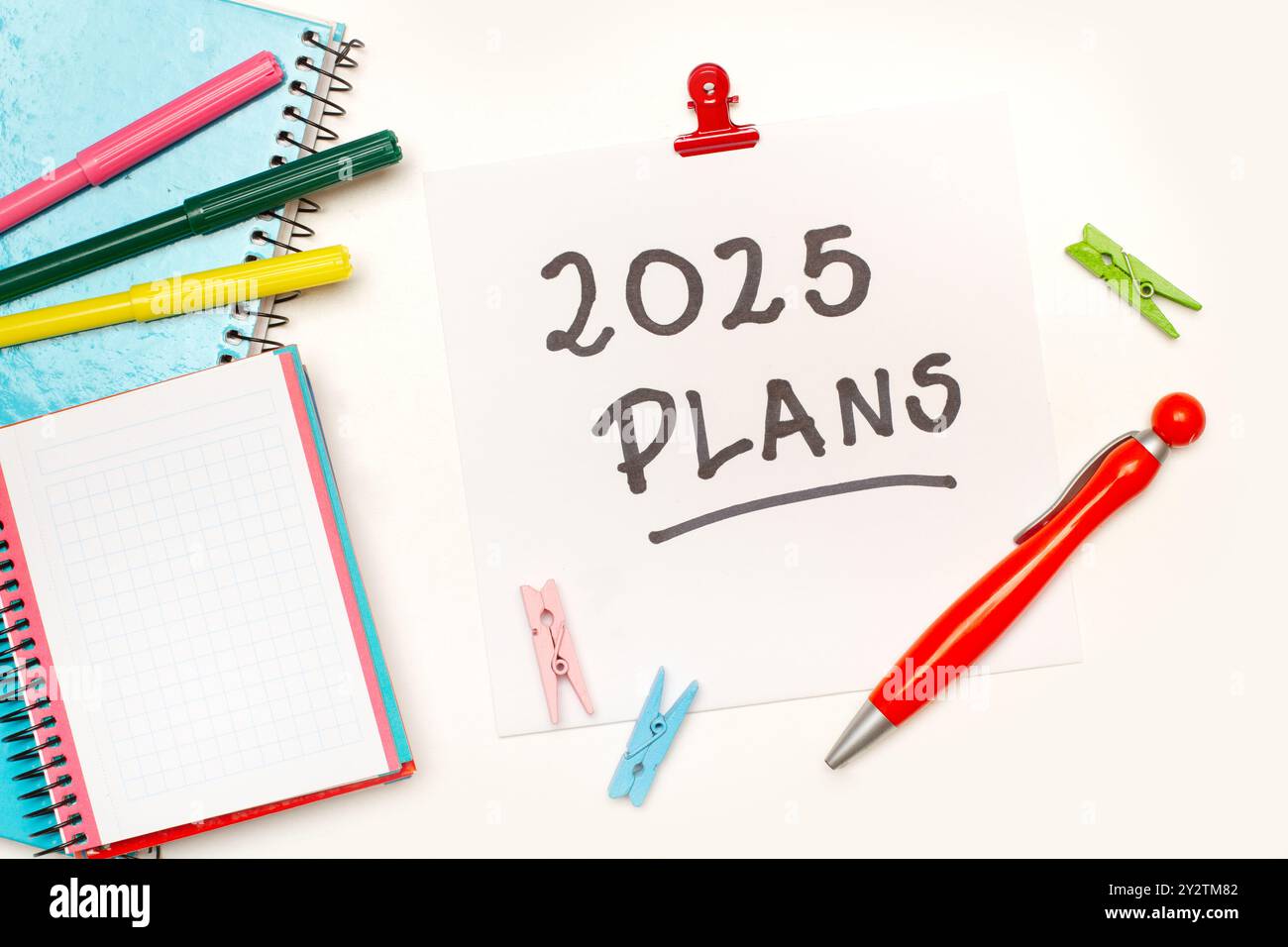 Notepads, markers and a sheet of paper with 2025 plans phrase written ...