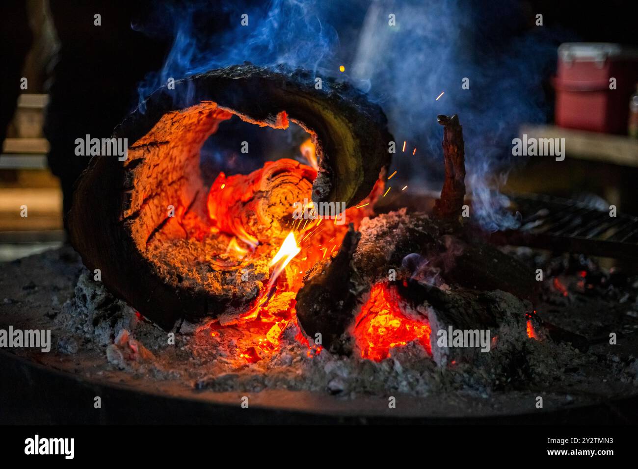 A captivating image of a fire, casting a warm glow and smoke around it ...