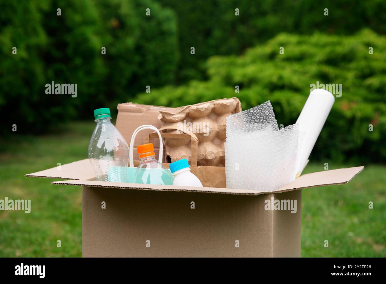 Recycling. Different garbage in cardboard box outdoors Stock Photo - Alamy
