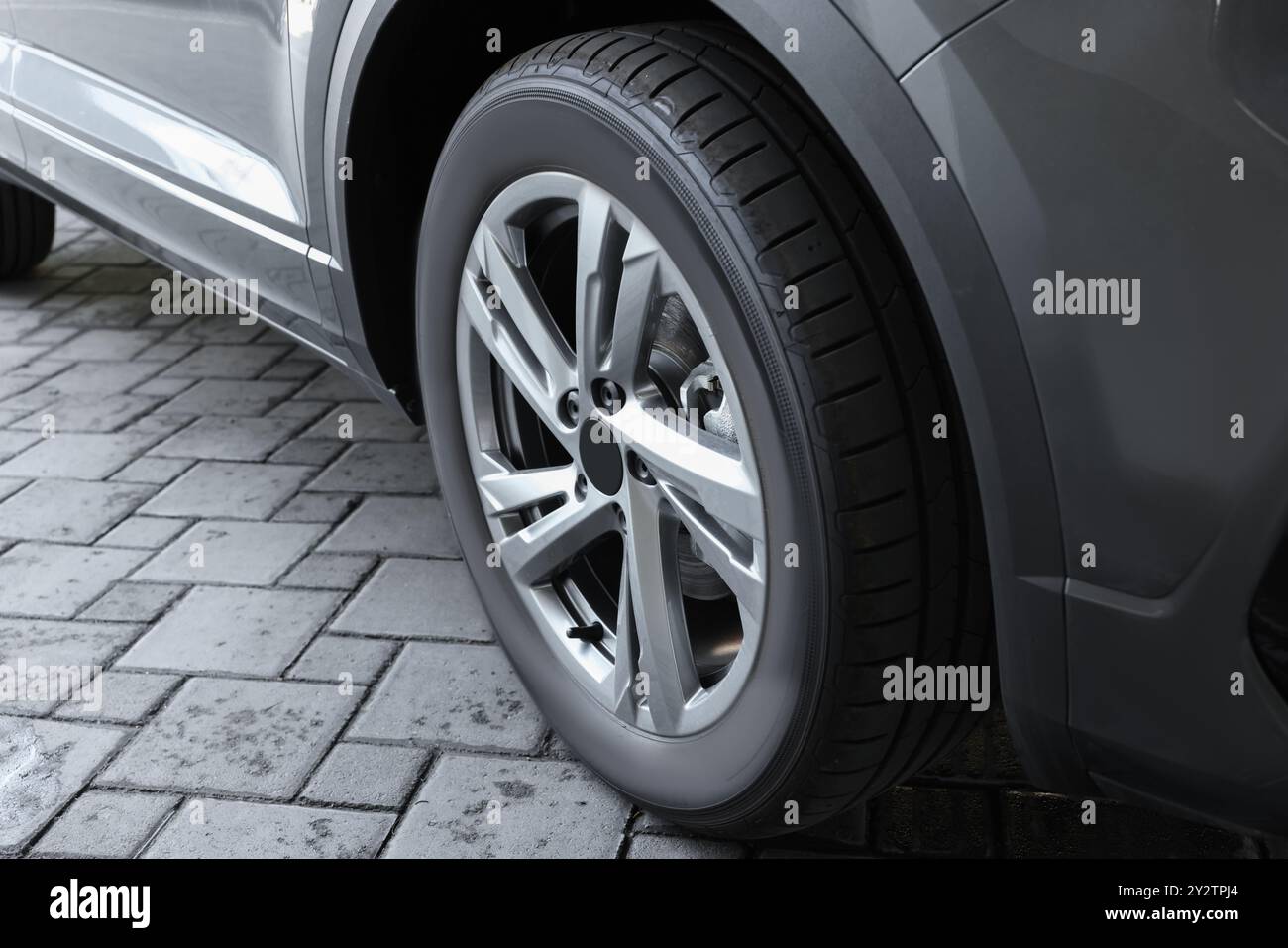 Modern grey car parked on paved road, closeup Stock Photo - Alamy