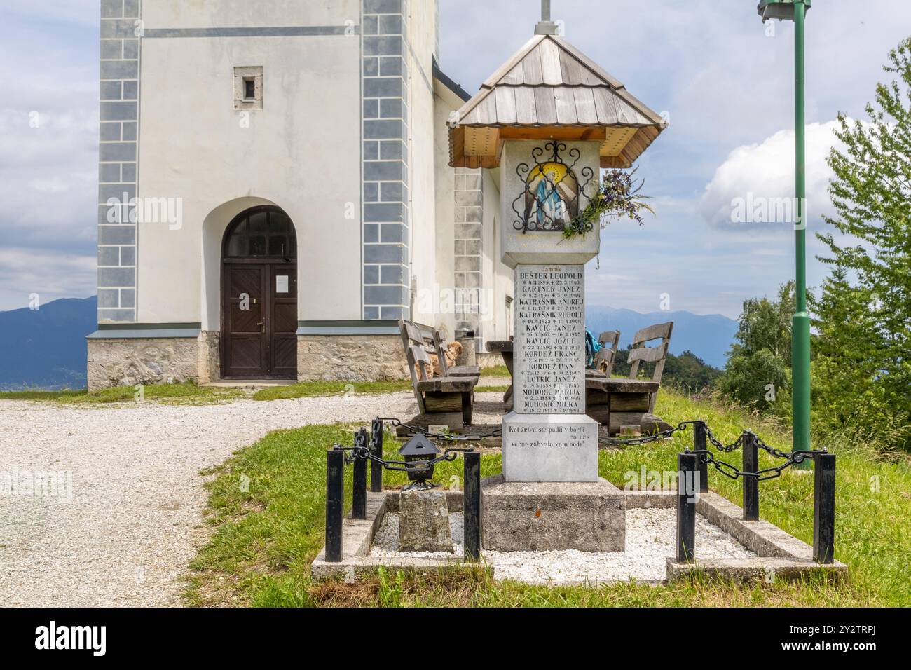 A small chapel with a memorial monument in a scenic mountainous area ...