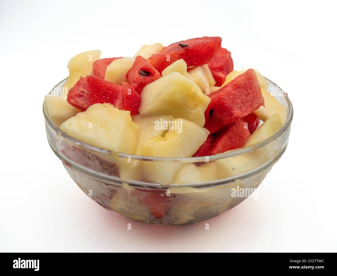 A clear glass bowl filled with fresh watermelon and pineapple chunks ...