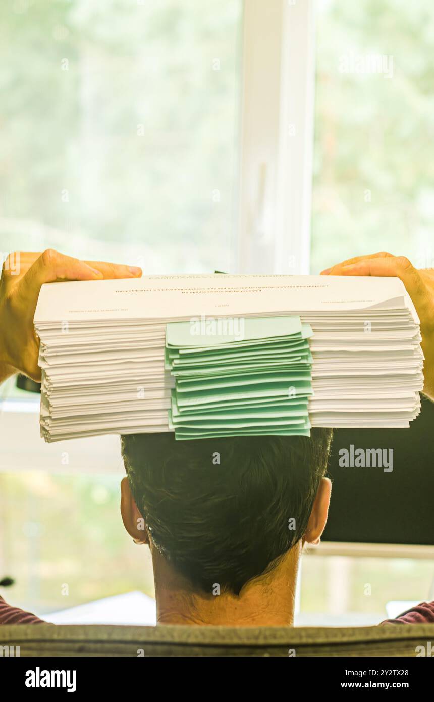 male holds stack of paper on his head in front of window . High quality ...