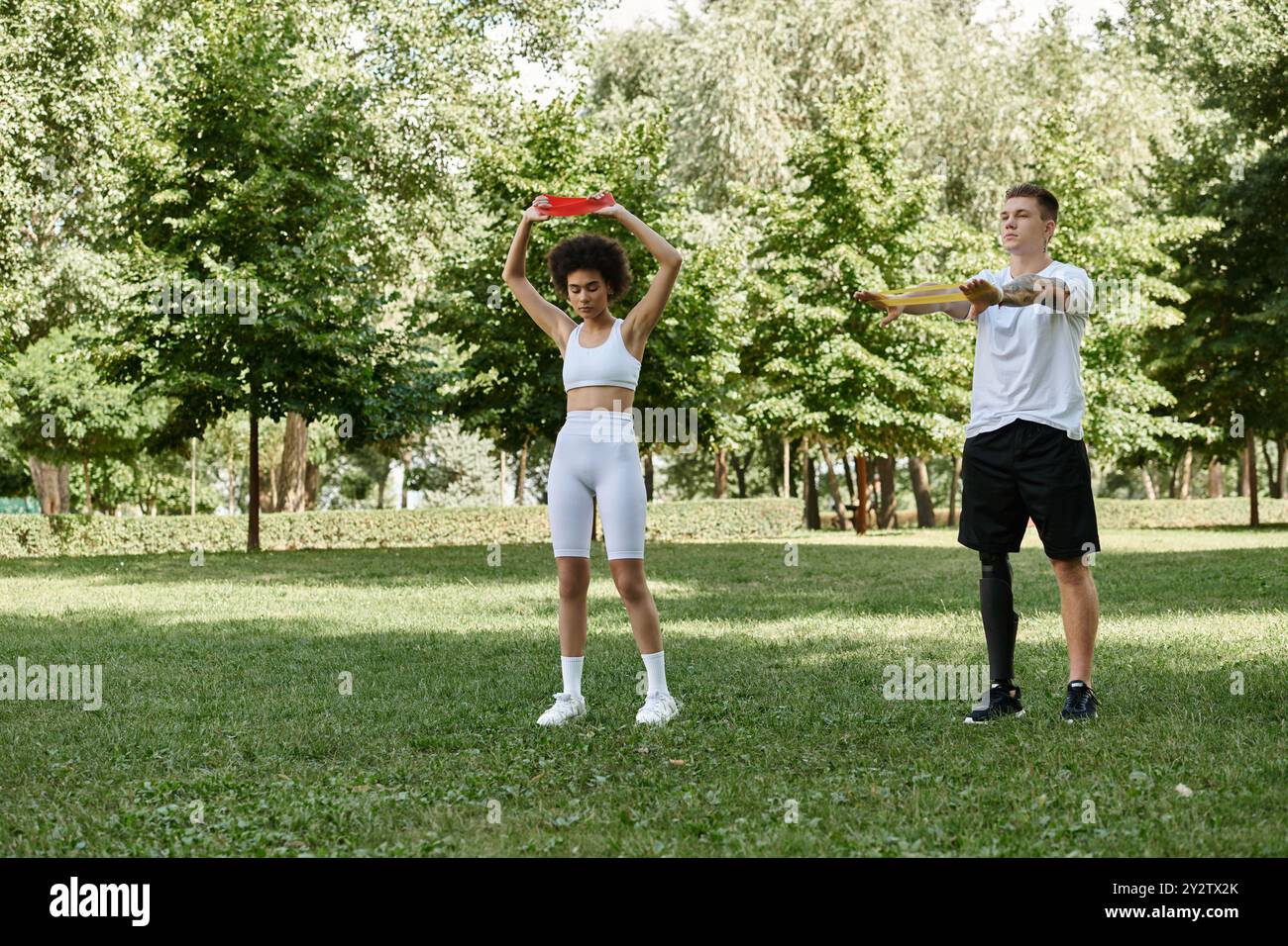 Two friends are actively working out together in a lush green park ...