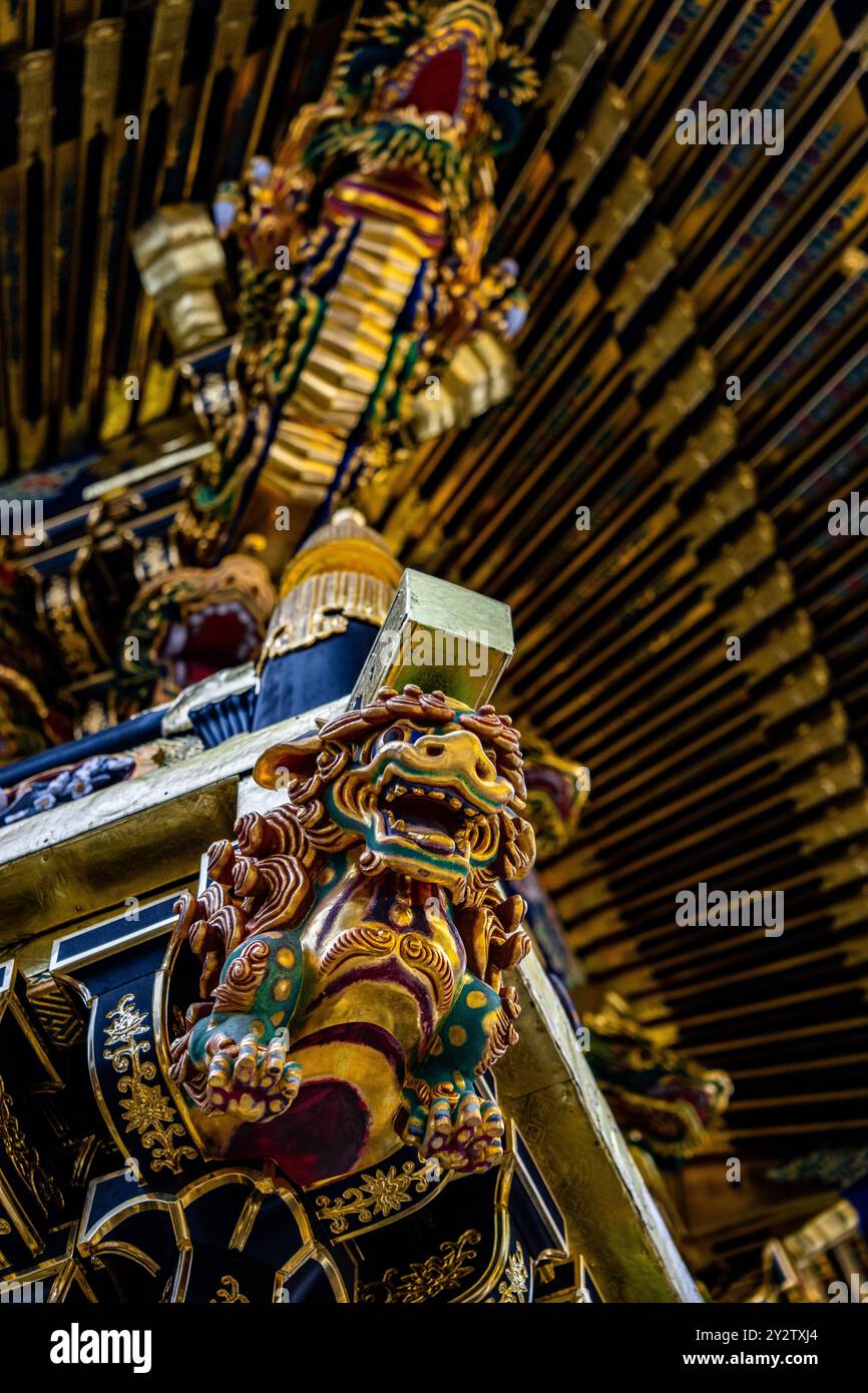 An ancient ornate Yomeimon gate with golden spirit protector statues at ...