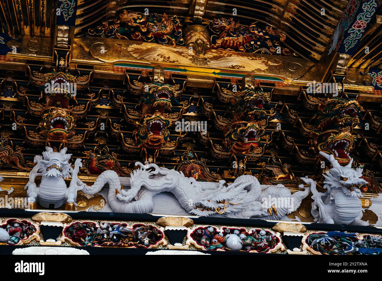 An ancient ornate Yomeimon gate with golden spirit protector statues at ...