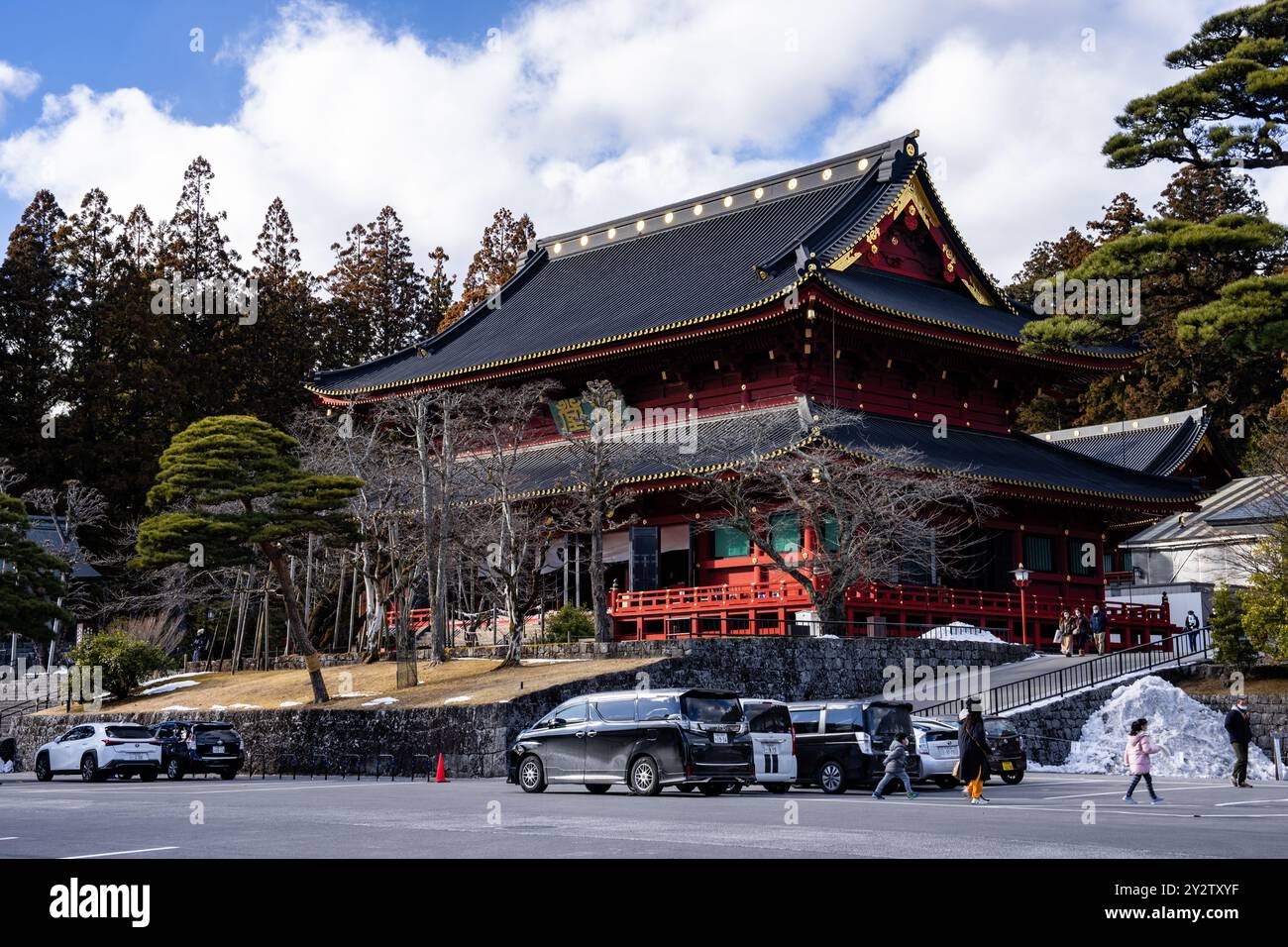A traditional Japanese temple with people walking in front, set against ...
