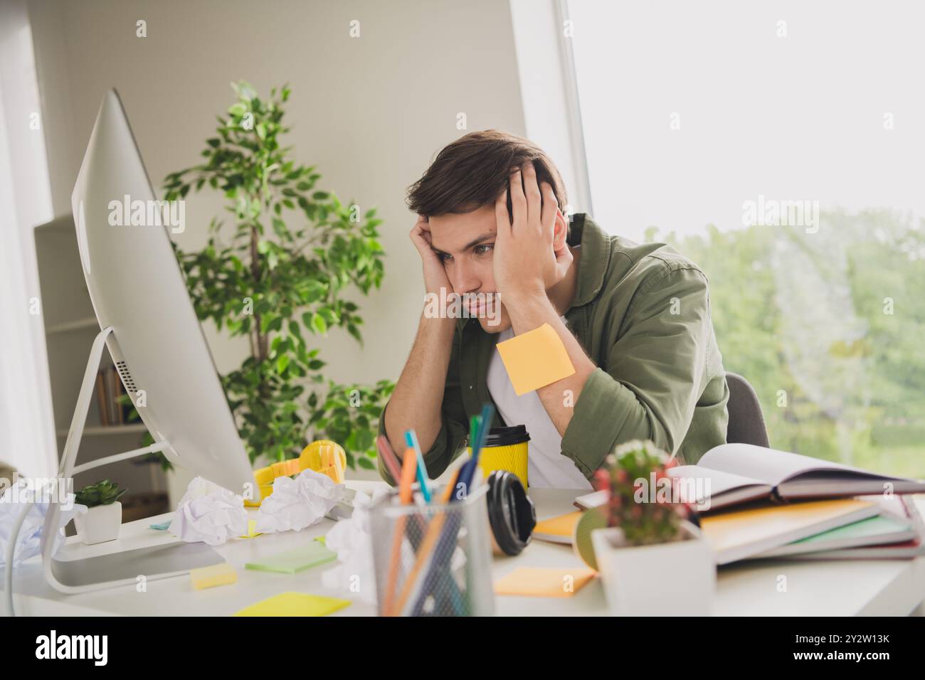 Photo of bored upset man assistant agent working modern device drink ...