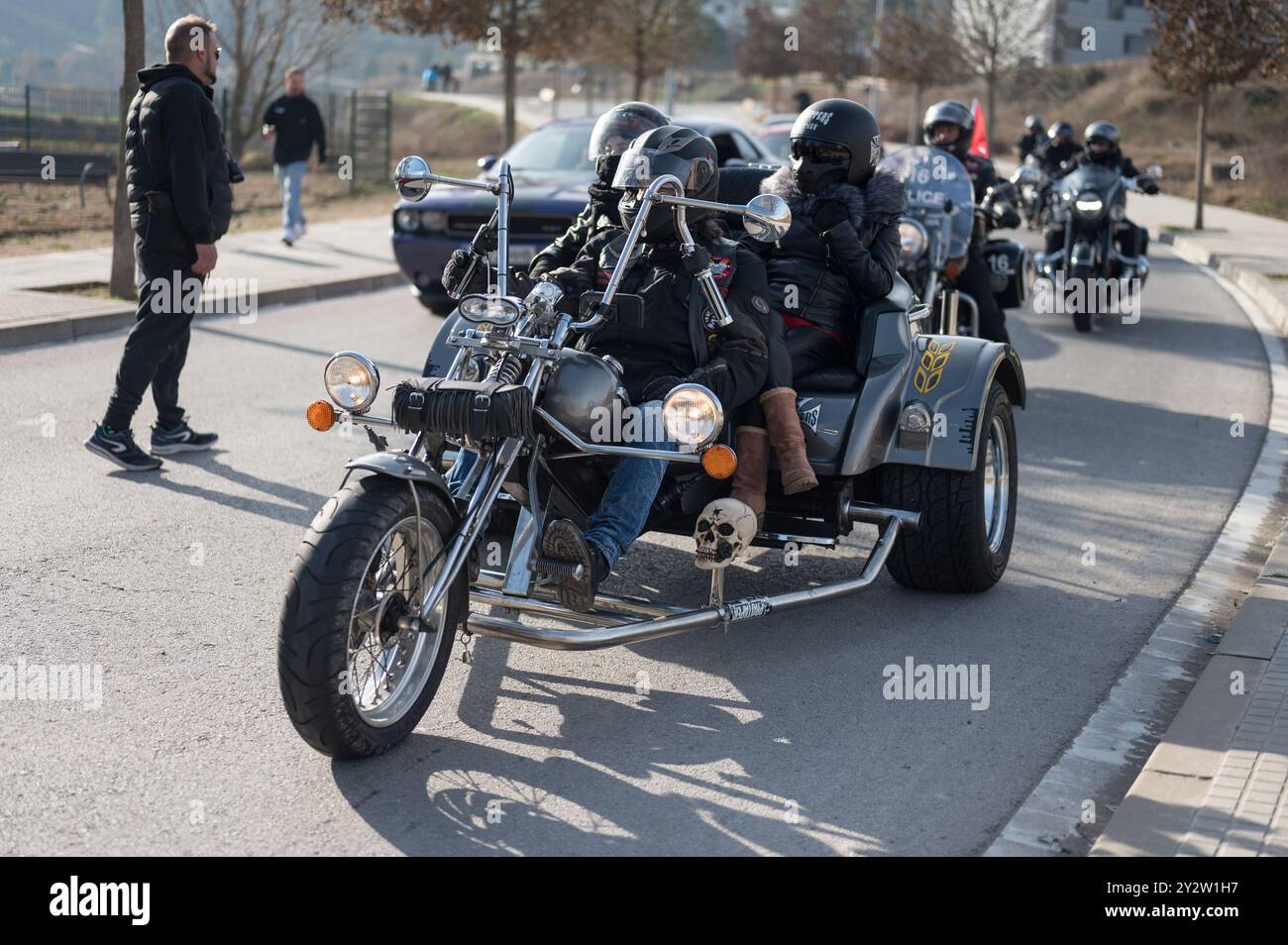 Front view of a black custom 3 wheel trike motorcycle with 3 passengers ...