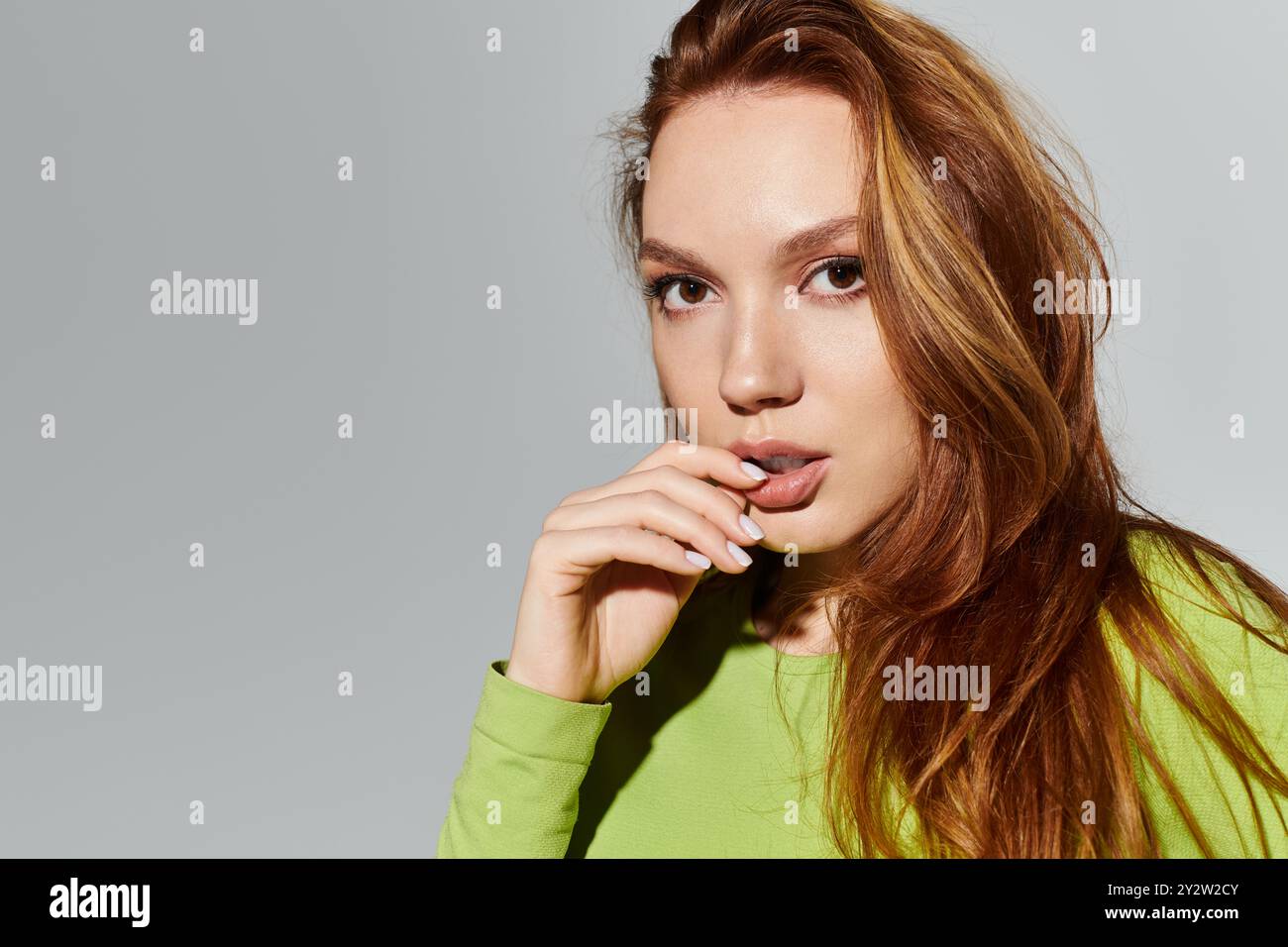 A fashionable woman captures attention with her red hair and confident ...