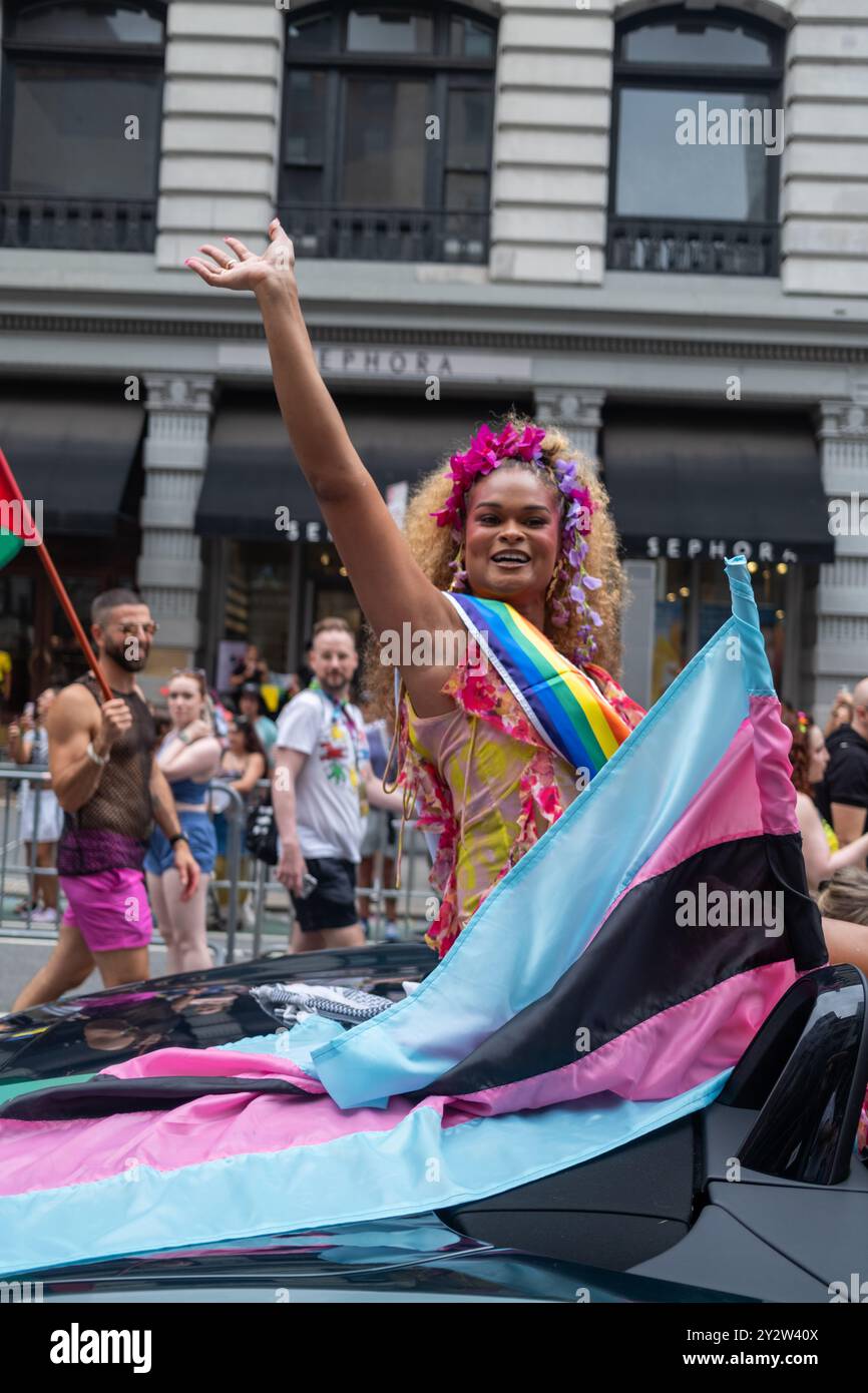 Raquel Willis, Grand Marshall, waving a pride flag while participating ...