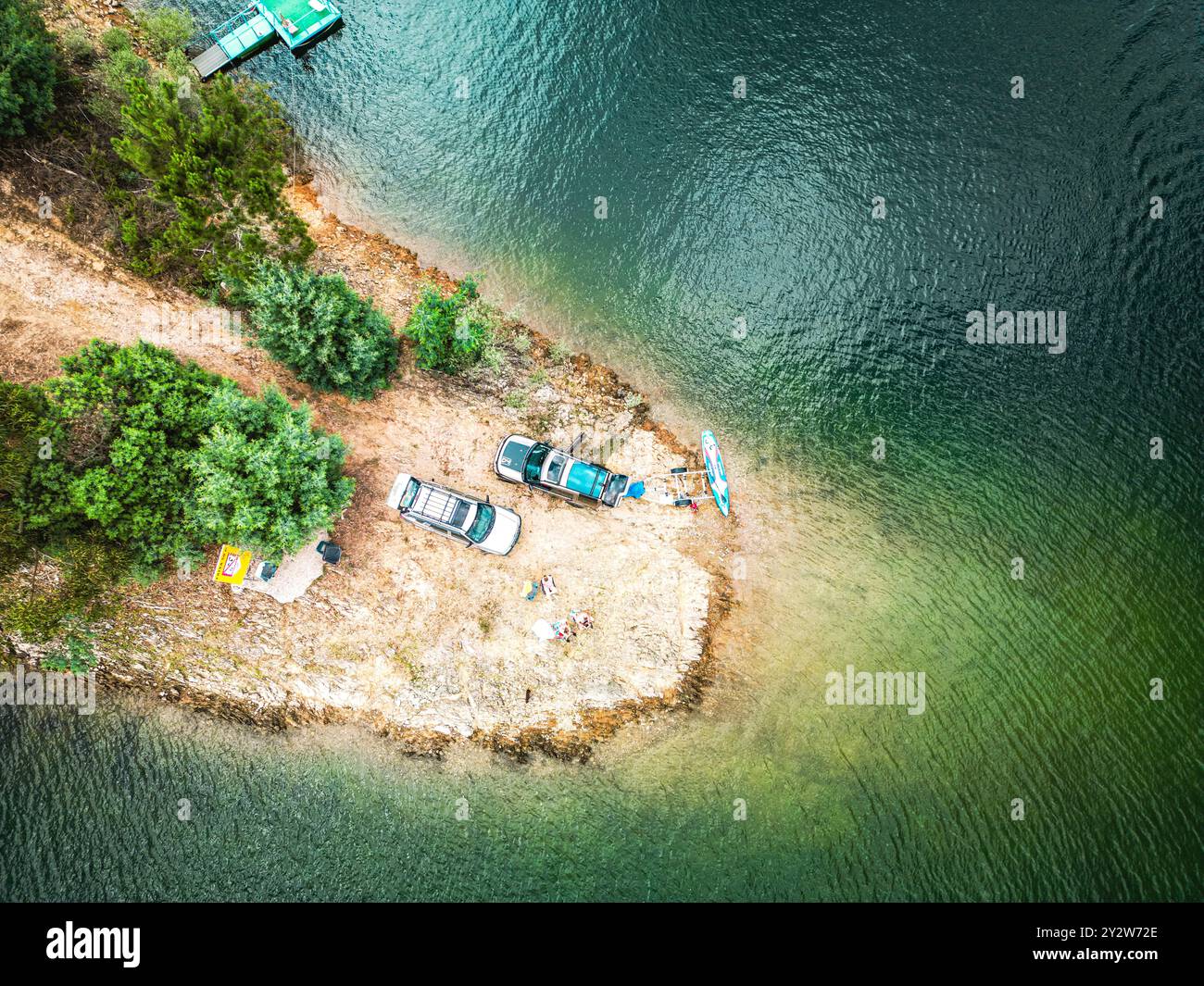 Aerial view of a small peninsula with vehicles, trees, and people near ...