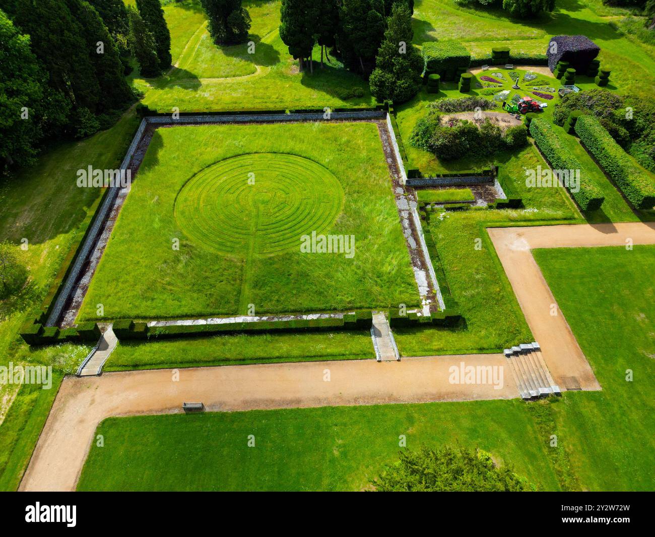 Aerial view of a manicured garden with a circular labyrinth design and ...
