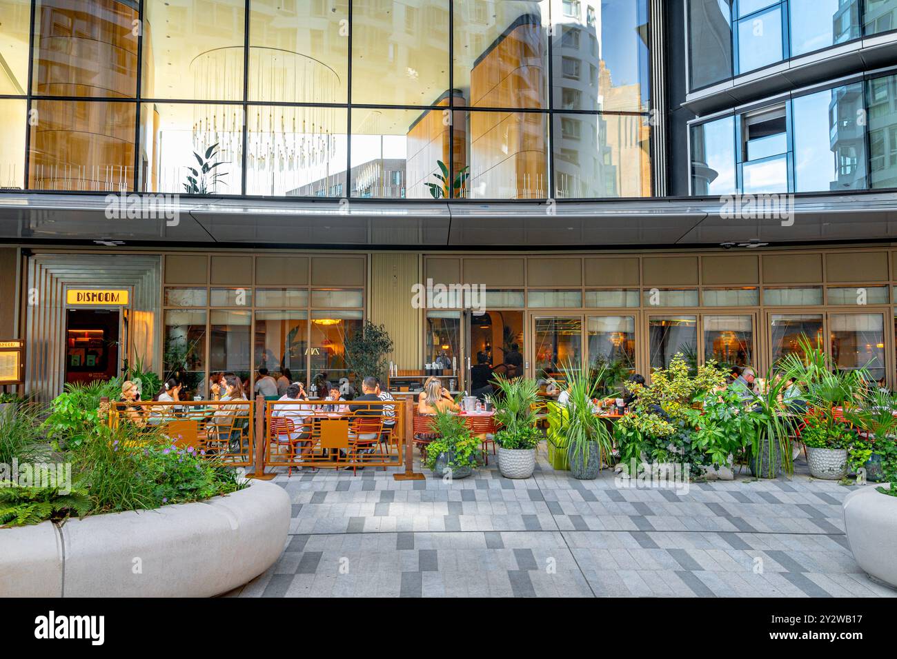 People eating outside on the terrace at Dishoom Battersea , a popular ...