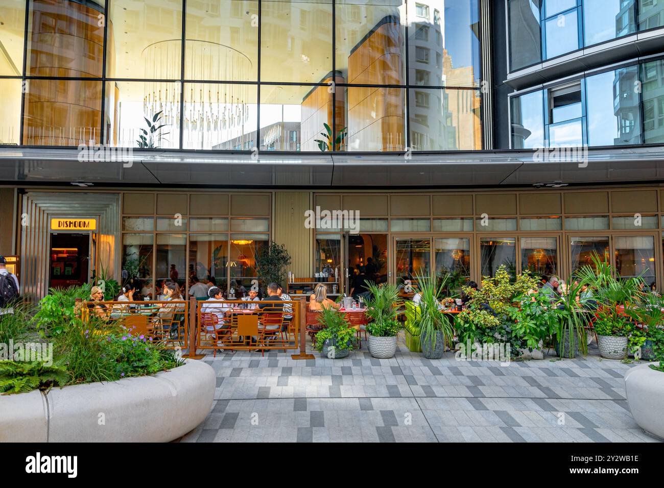 People eating outside on the terrace at Dishoom Battersea , a popular ...